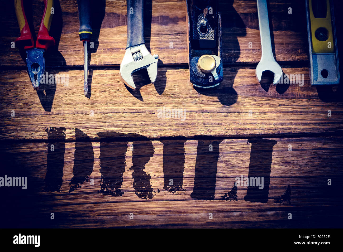 Drill against desk with tools Stock Photo - Alamy