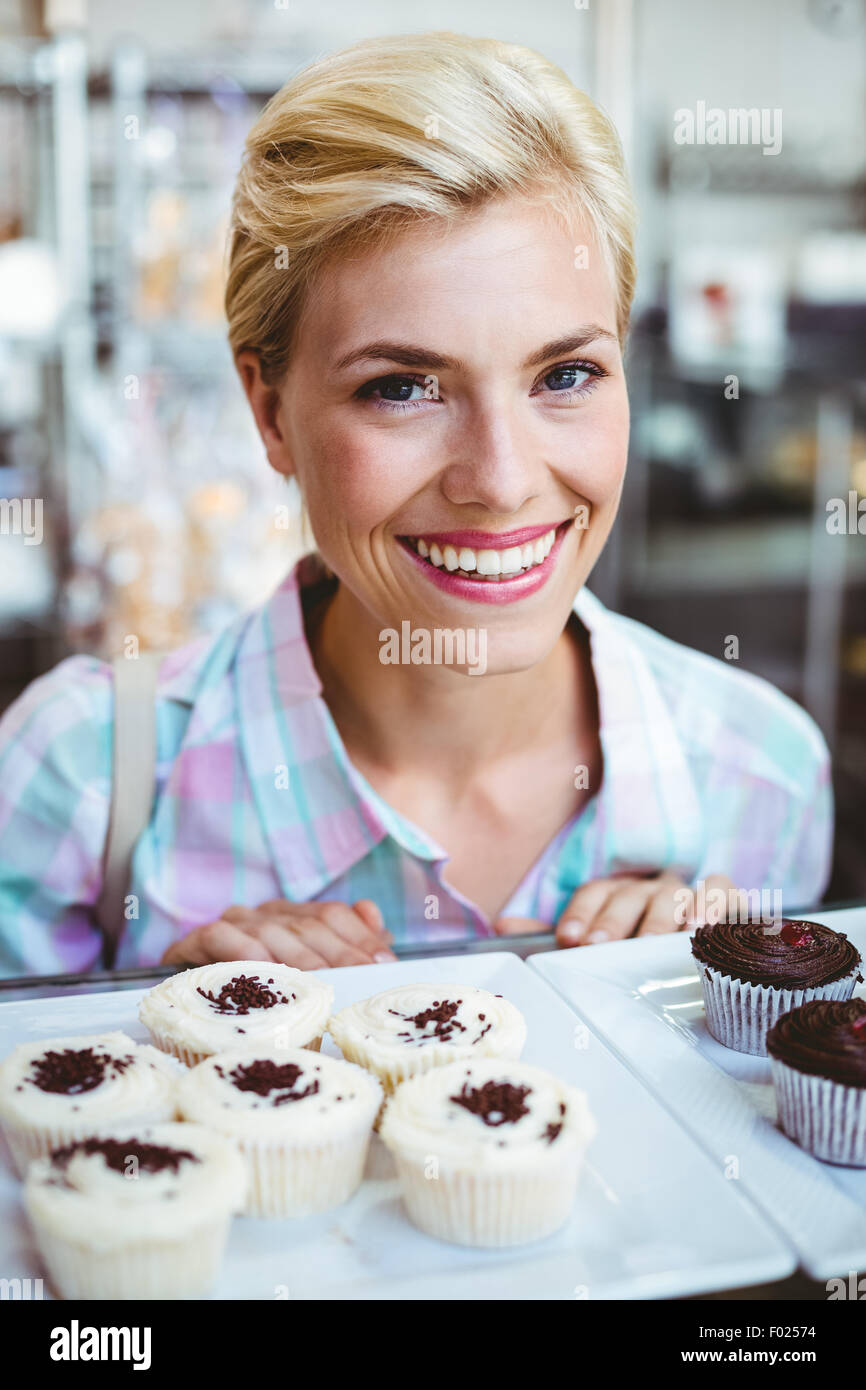 Pretty woman looking at cup cakes Stock Photo - Alamy