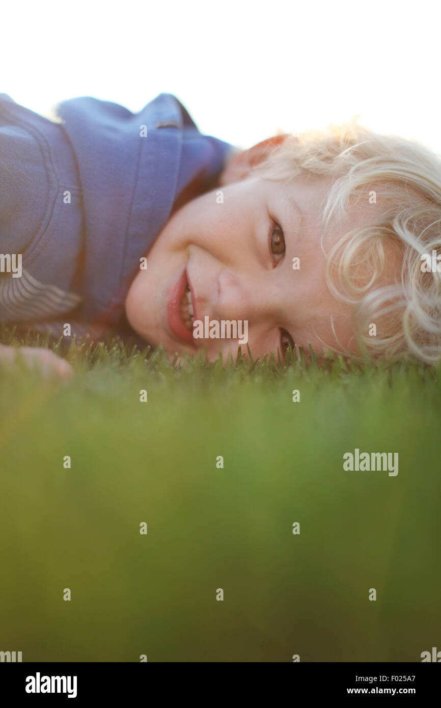 Portrait of a Boy lying on the grass Stock Photo - Alamy