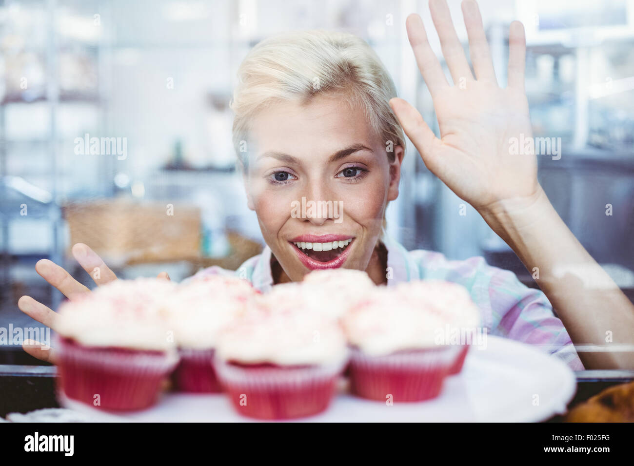 Astonished pretty woman looking at cup cakes Stock Photo - Alamy