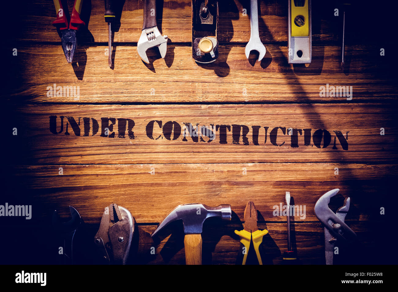 Under construction against desk with tools Stock Photo - Alamy