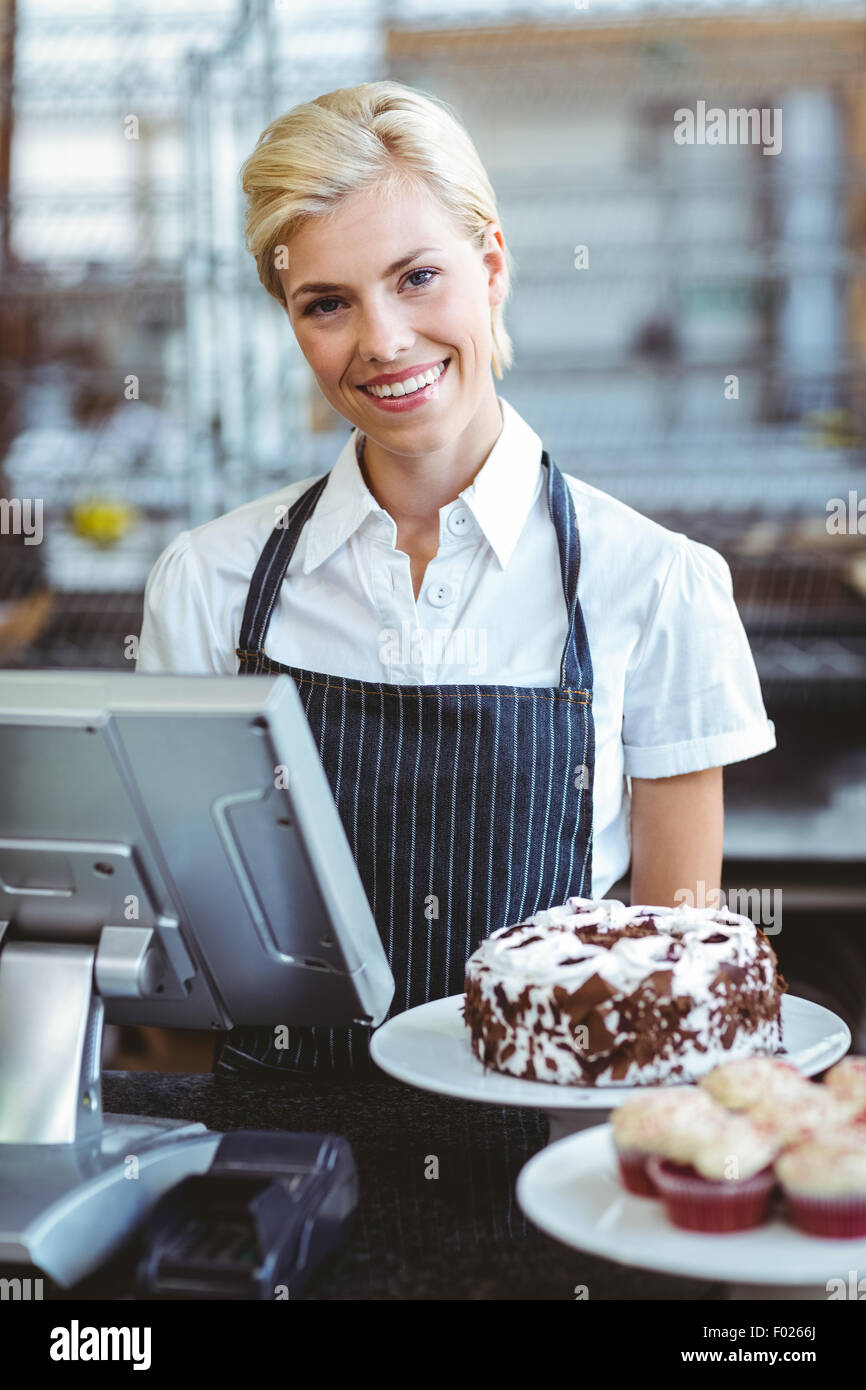 Smiling employee using calculator on counter Stock Photo - Alamy
