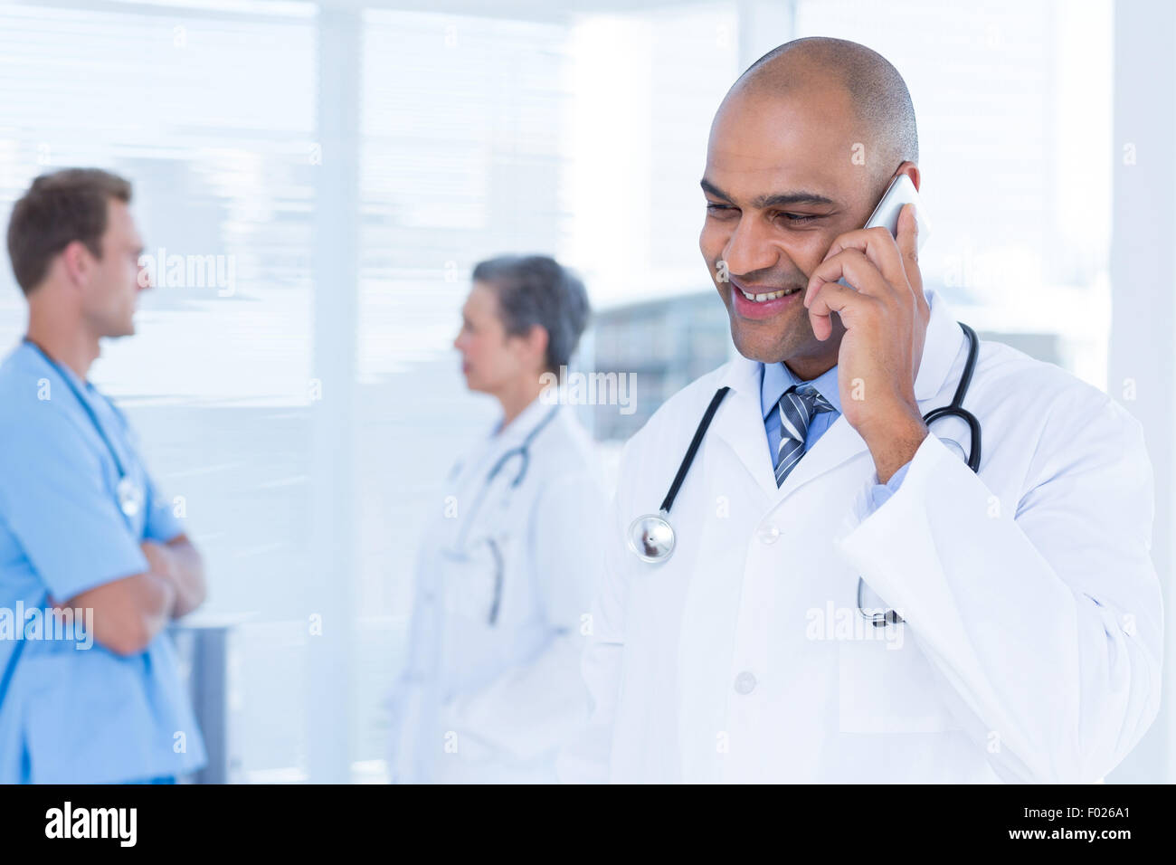 Smiling doctor talking on the phone Stock Photo - Alamy