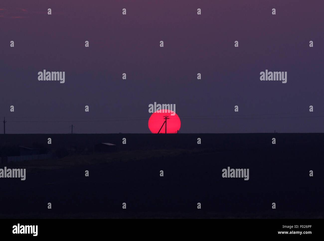 view on electricity pole over rising sun Stock Photo - Alamy
