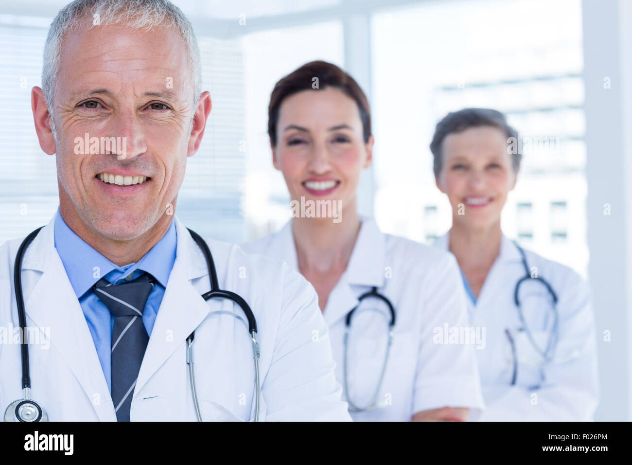 Portrait of three smiling medical colleagues looking at camera Stock ...