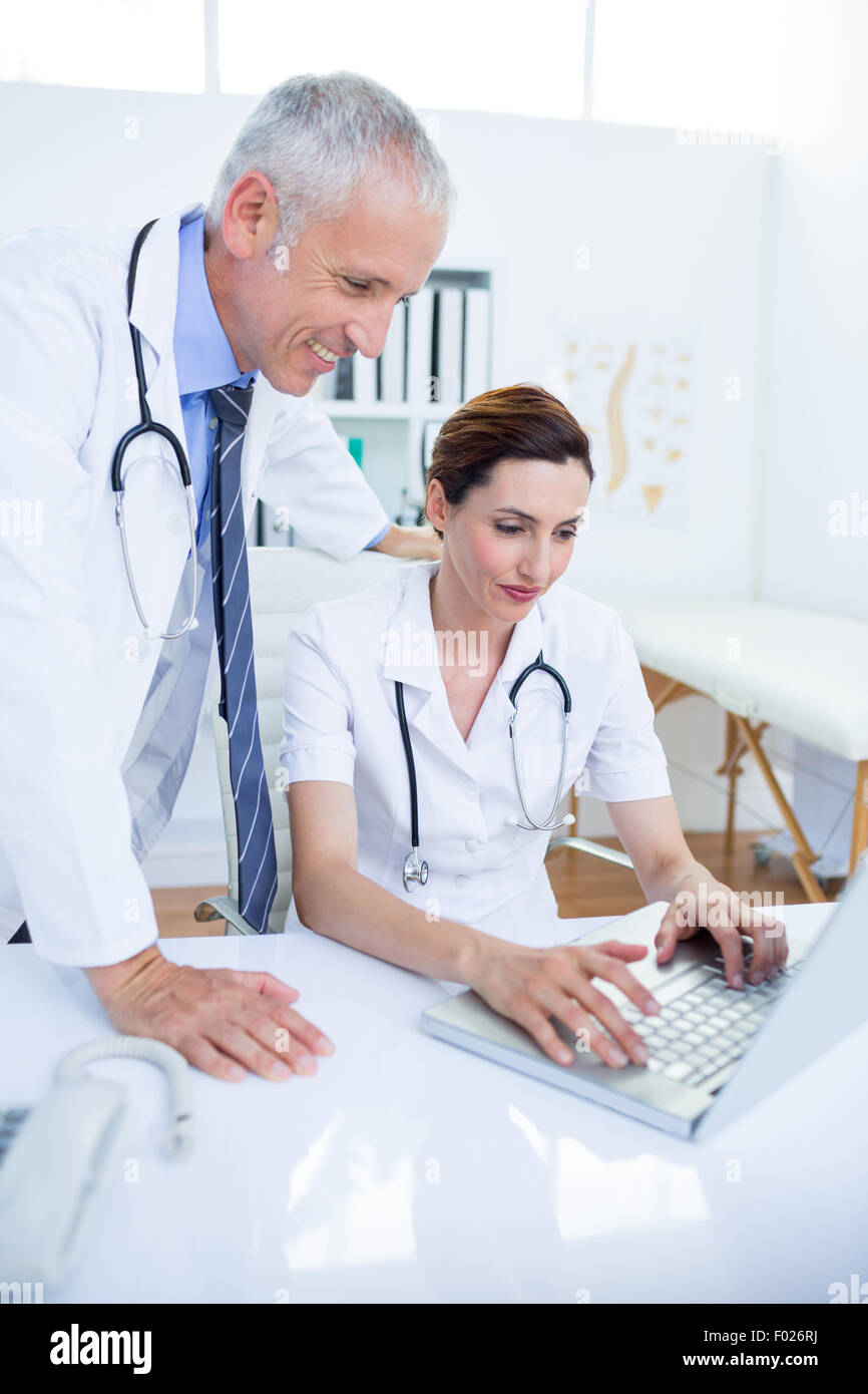 Smiling medical colleagues working with laptop Stock Photo - Alamy