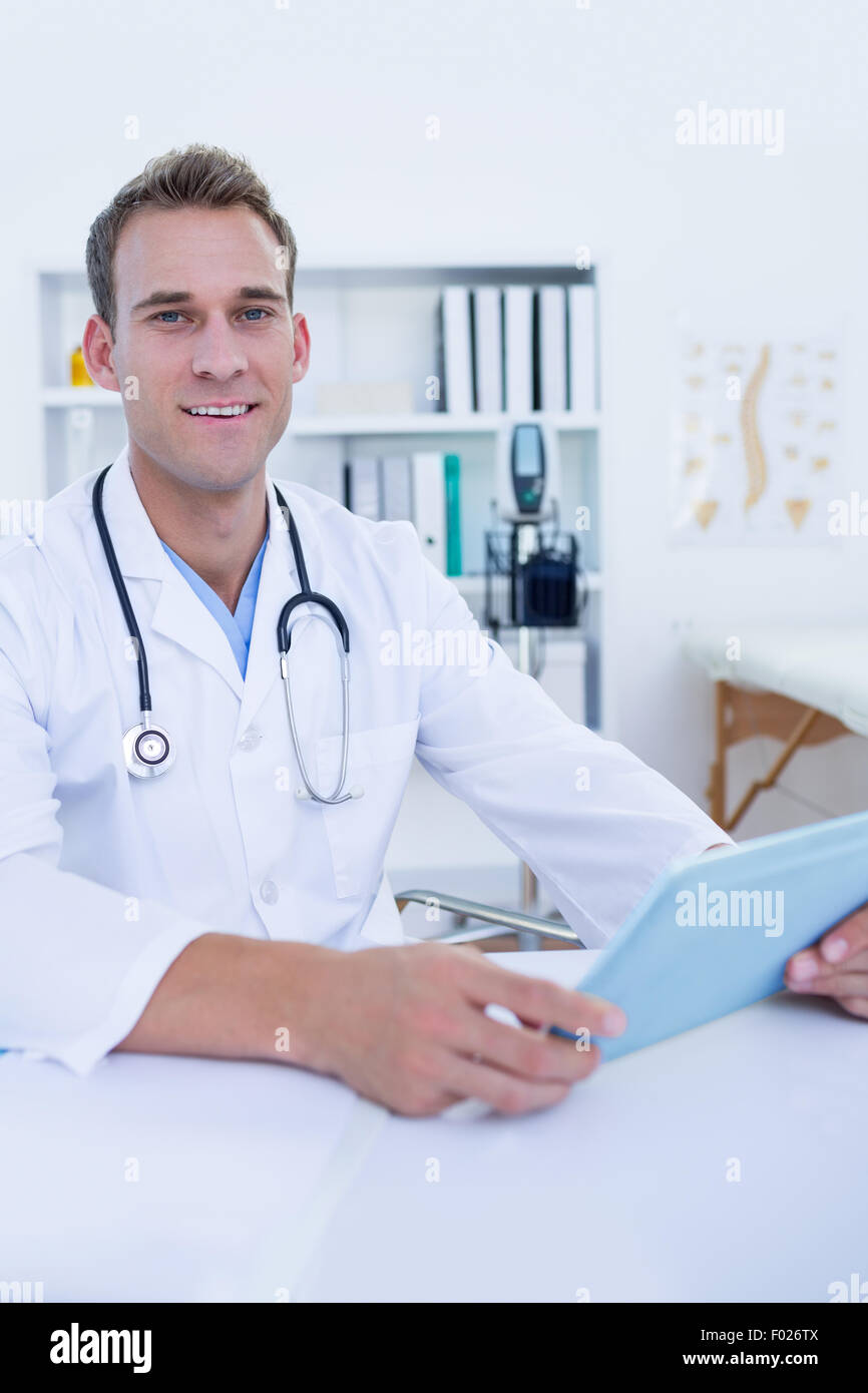 Happy doctor looking at camera and using tablet computer Stock Photo ...
