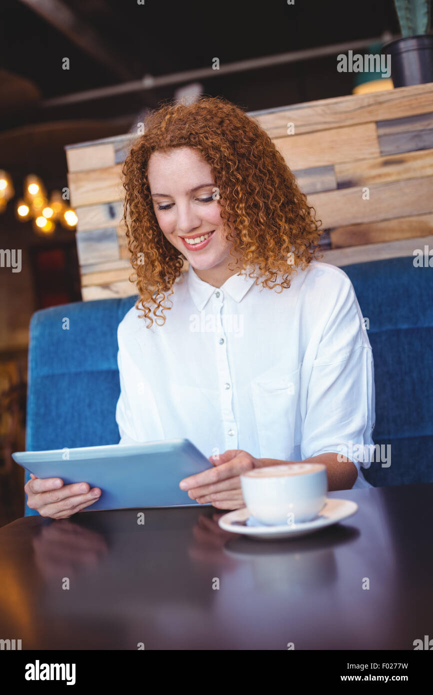 Pretty girl using a small tablet at table Stock Photo - Alamy