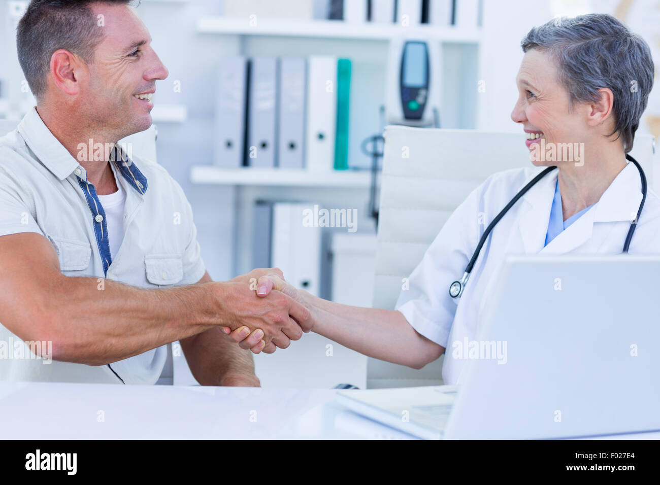 Doctor shaking and of her patient Stock Photo - Alamy