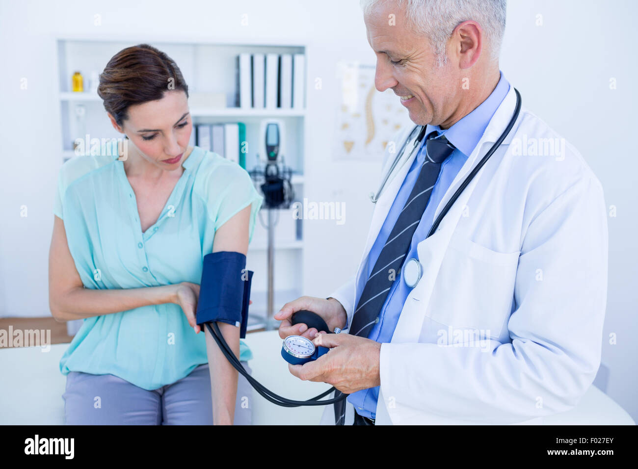 Doctor checking blood pressure of a young woman Stock Photo - Alamy