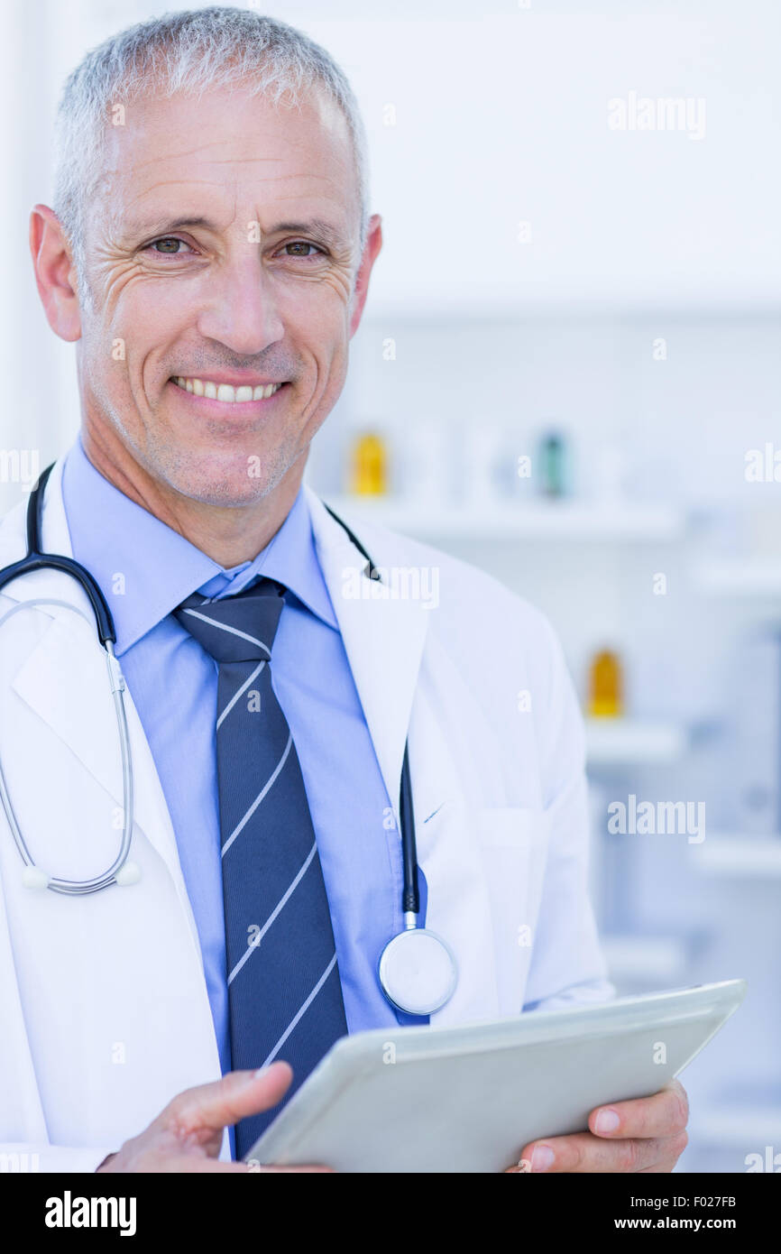 Doctor looking at camera and holding clipboard Stock Photo - Alamy