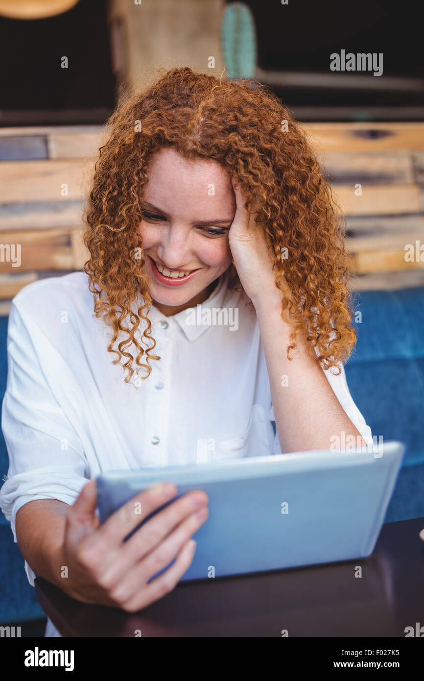 Pretty girl using a small tablet at table Stock Photo - Alamy