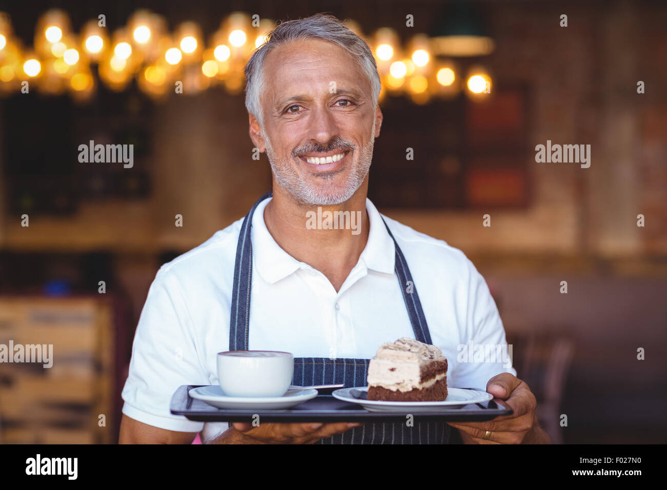 waiter smiling and holding tray Stock Photo - Alamy