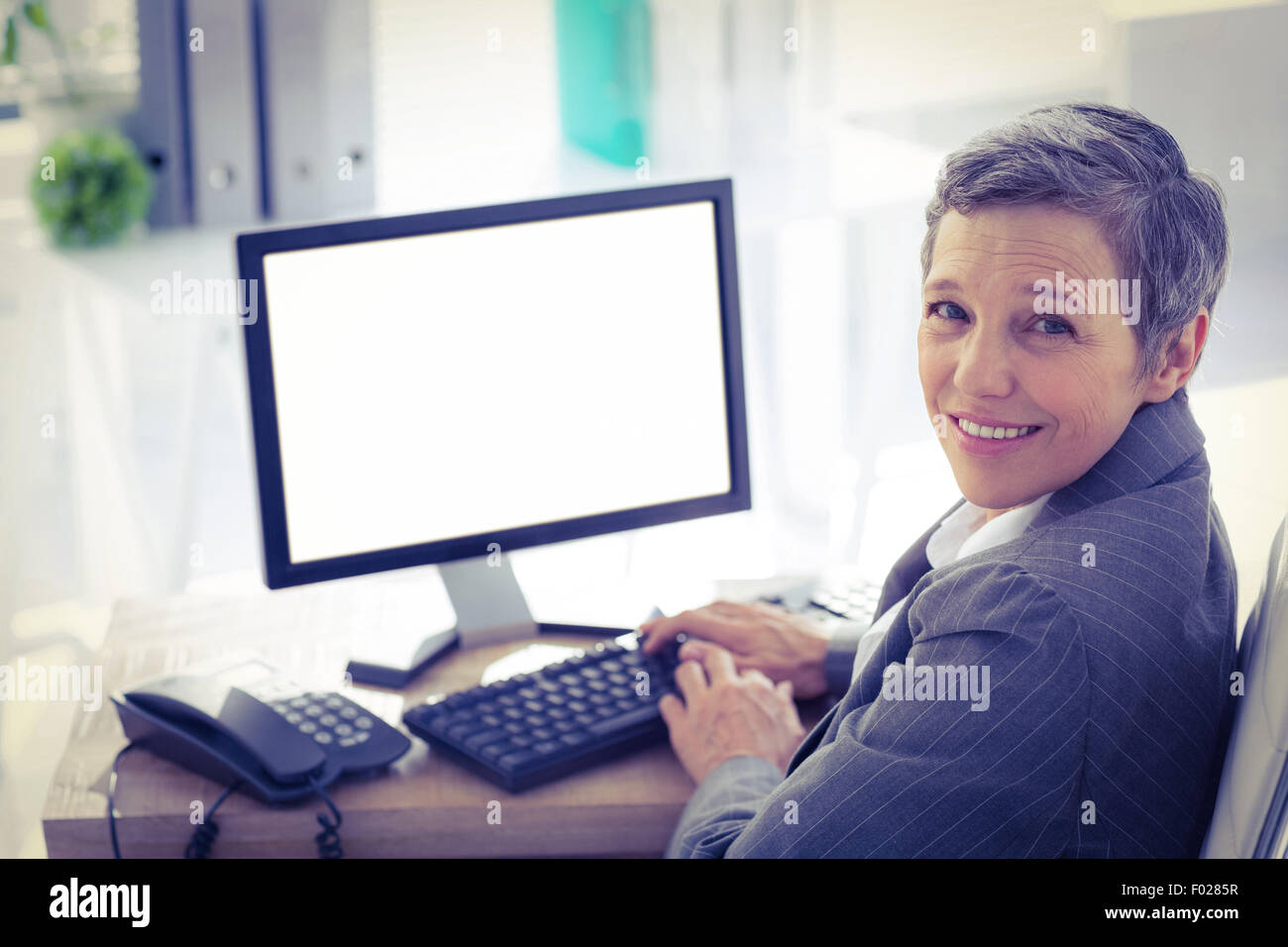 Smiling businesswoman using computer Stock Photo - Alamy