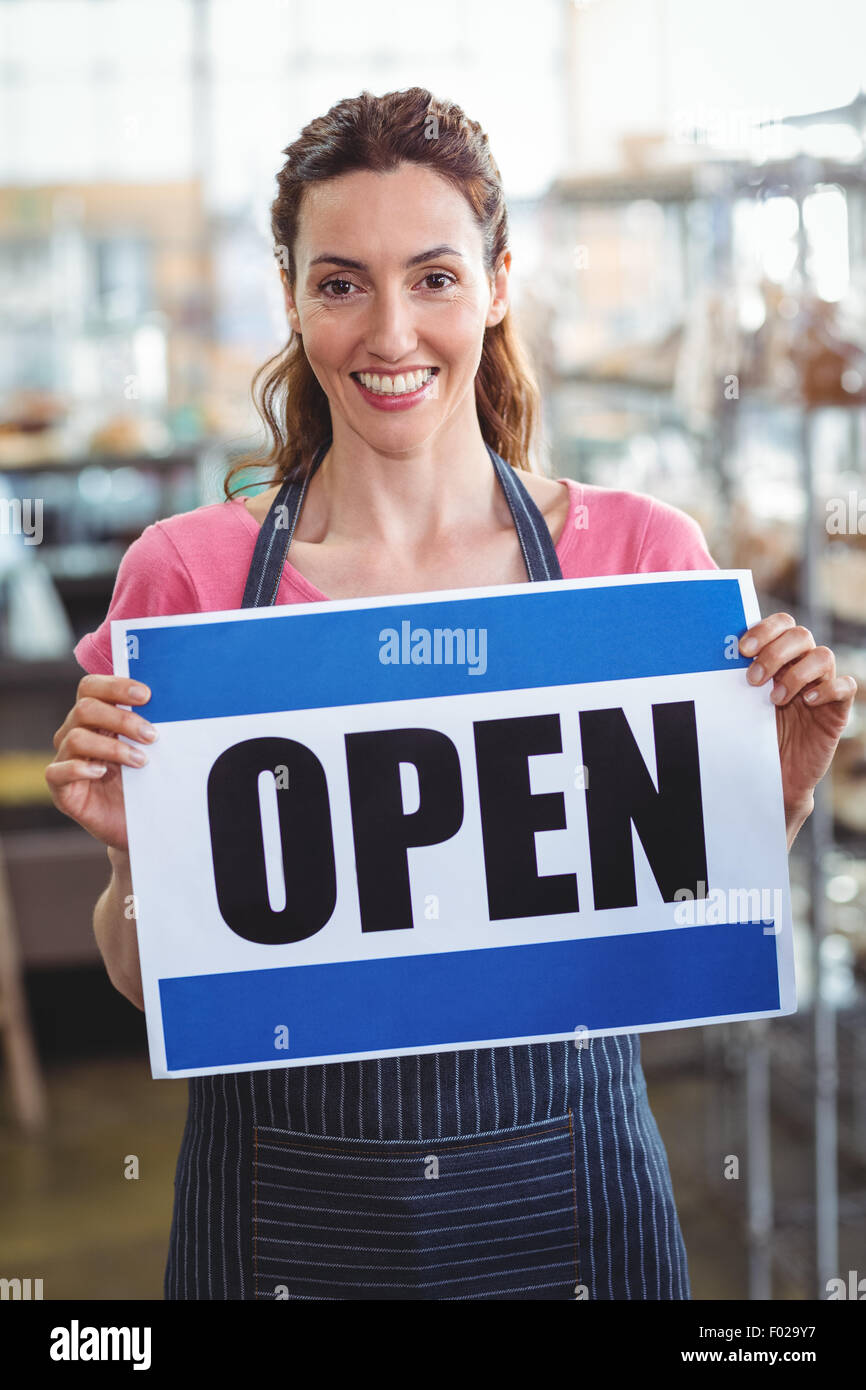 Pretty worker showing open sign Stock Photo - Alamy