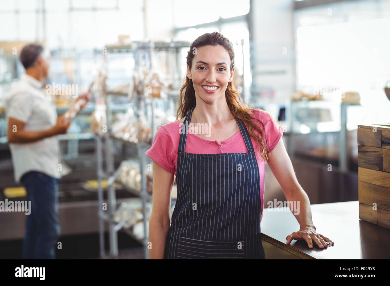 Pretty waitress leaning on counter Stock Photo - Alamy