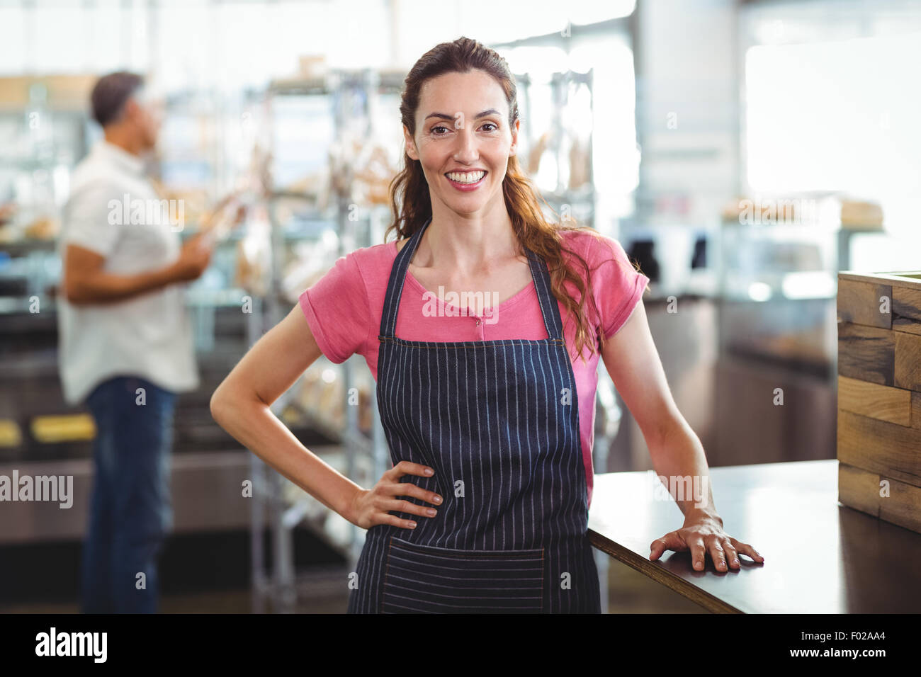 Pretty waitress leaning on counter Stock Photo - Alamy