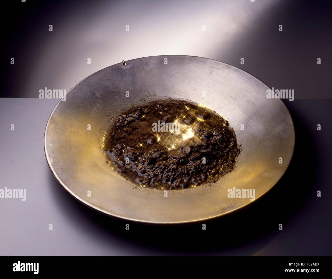 Gold pan for separating gold from river sand Stock Photo - Alamy