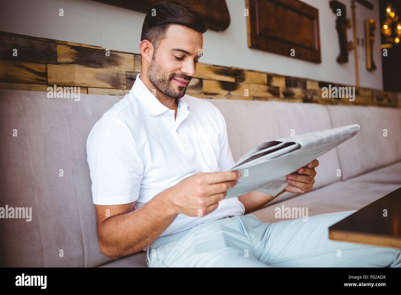 Young man reading a newspaper Stock Photo - Alamy