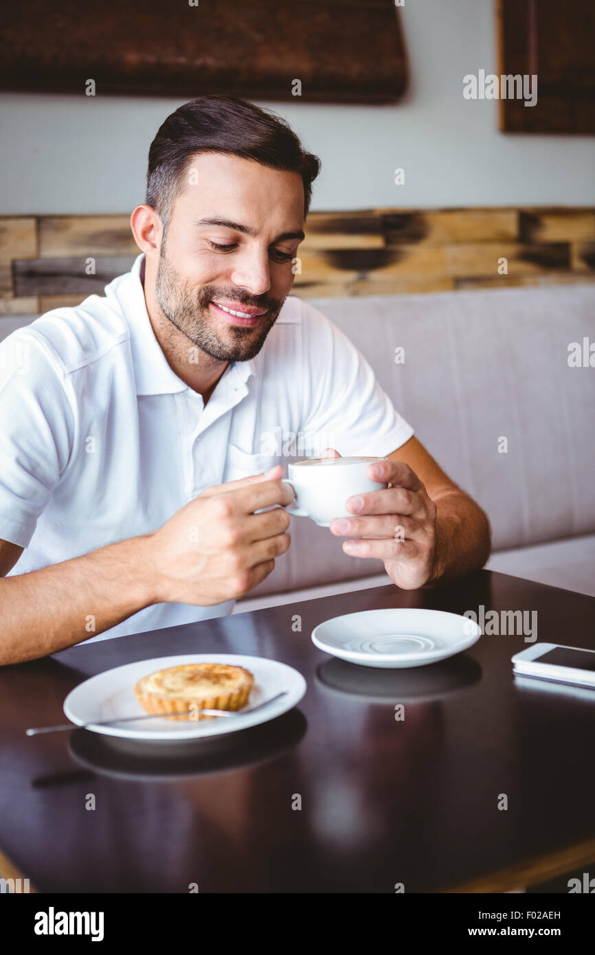 Young man drinking cup of coffee and pastry beside Stock Photo - Alamy
