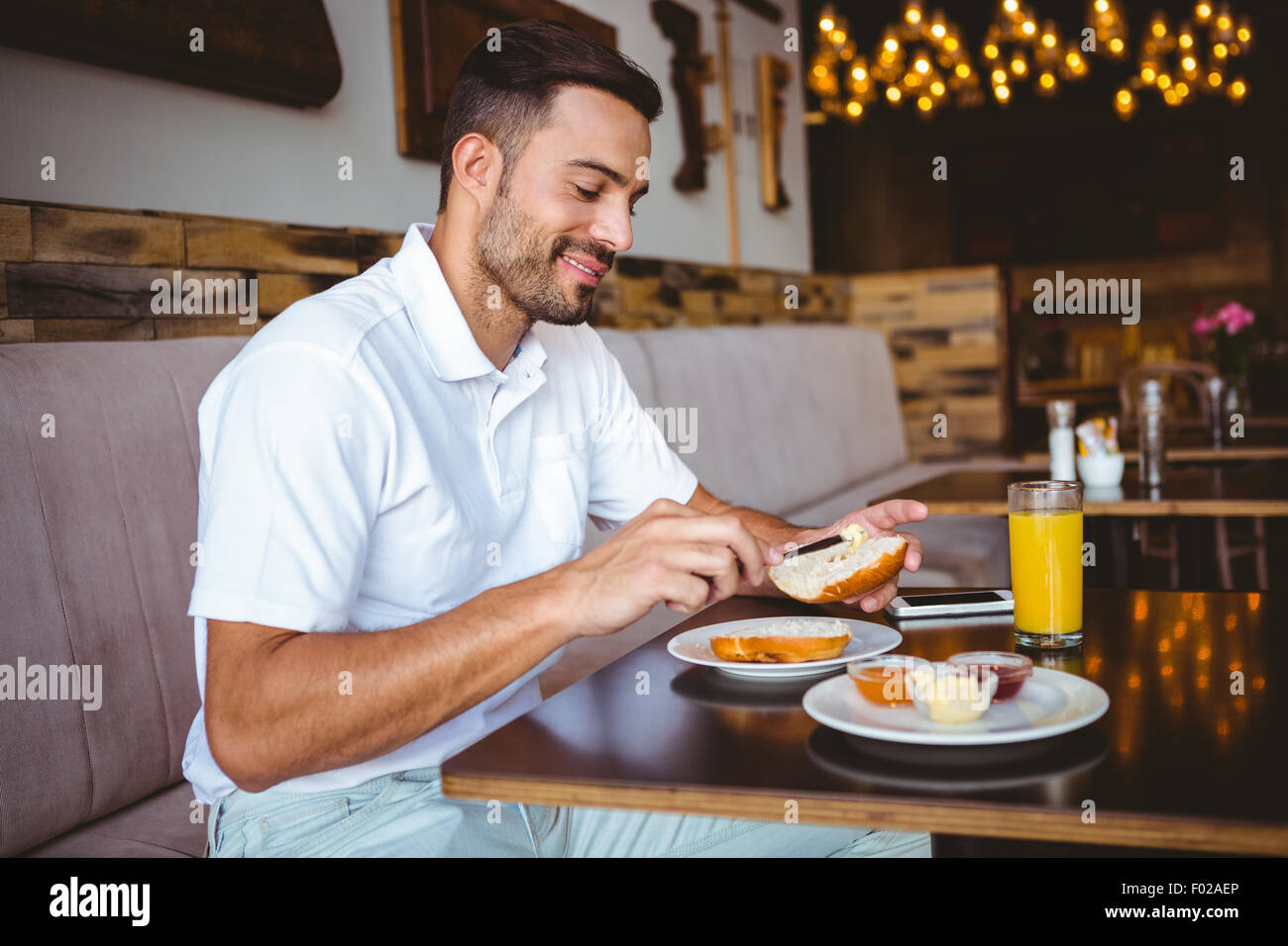Young man spreading butter on a toast Stock Photo - Alamy