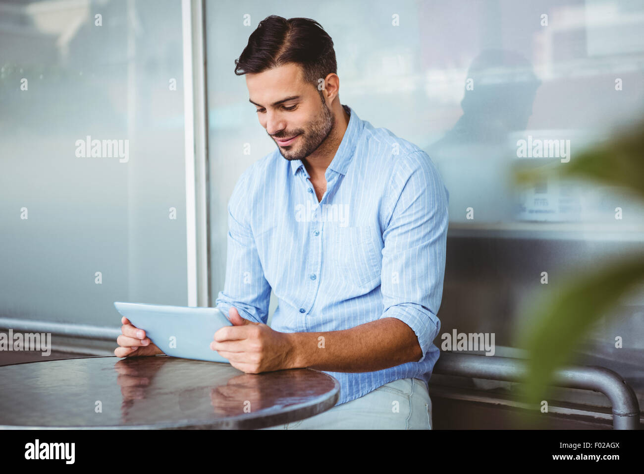 Smiling businessman using a tablet Stock Photo - Alamy