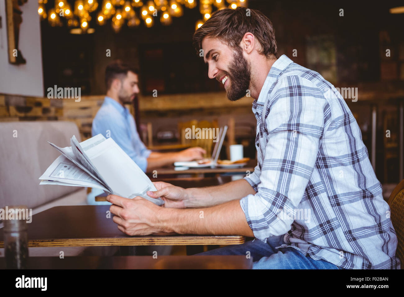 Young man reading a newspaper Stock Photo - Alamy