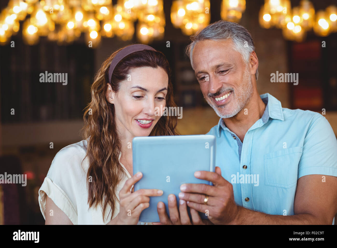 Happy couple using tablet together Stock Photo - Alamy