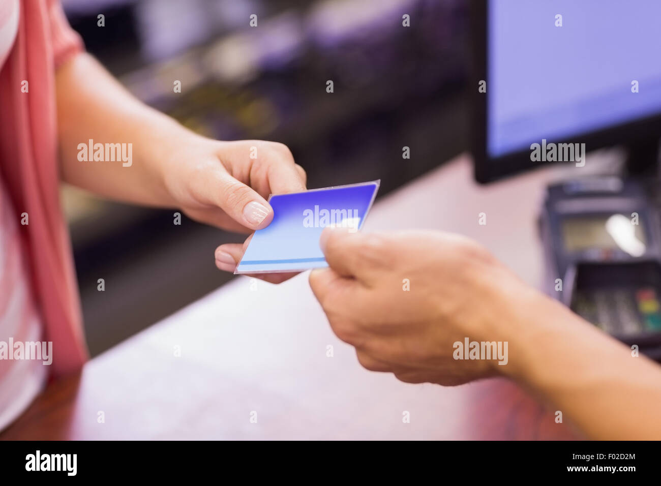 Woman at cash register paying with credit card Stock Photo - Alamy