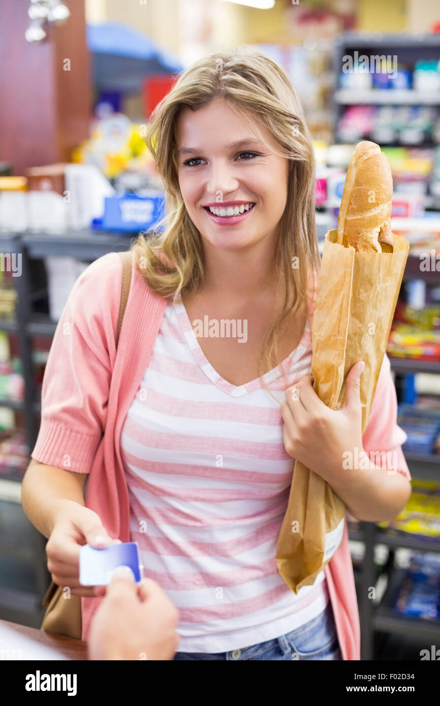 Smiling woman at cash register paying with credit card Stock Photo - Alamy