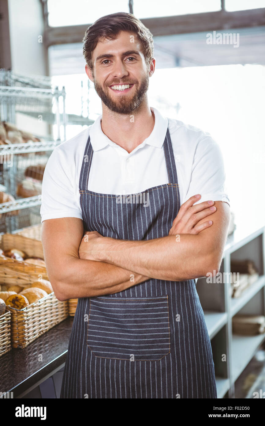 Smiling server in apron arm crossed Stock Photo - Alamy