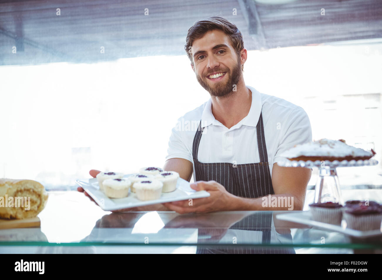 Smiling worker posing behind the counter Stock Photo - Alamy