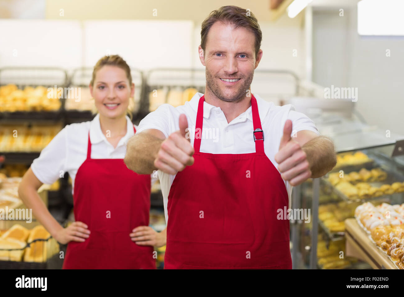 Portrait of smiling two bakers with thumb up Stock Photo - Alamy