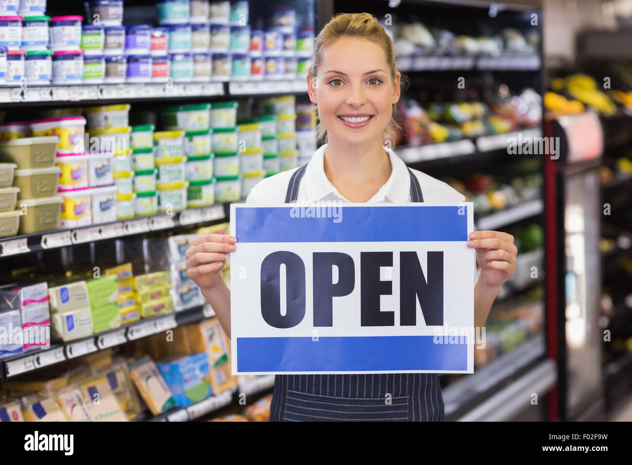Portrait of a smiling blonde worker holding a sign Stock Photo - Alamy