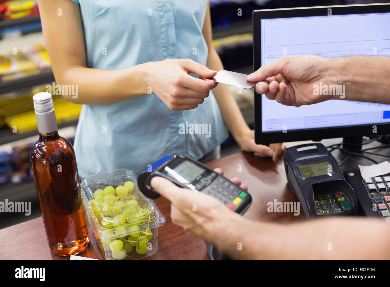 Woman at cash register paying with credit card Stock Photo - Alamy