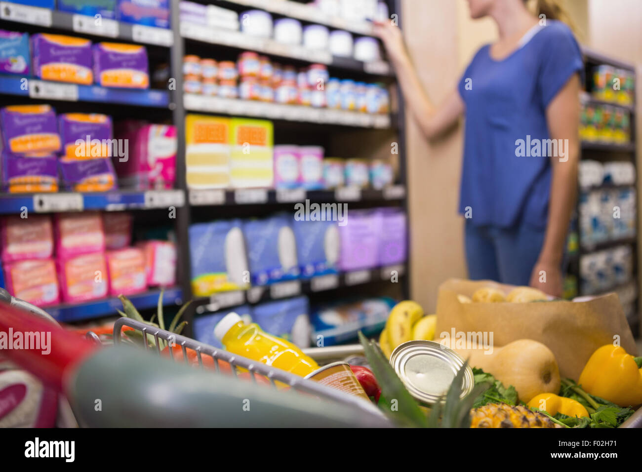Woman looking at product on self Stock Photo - Alamy