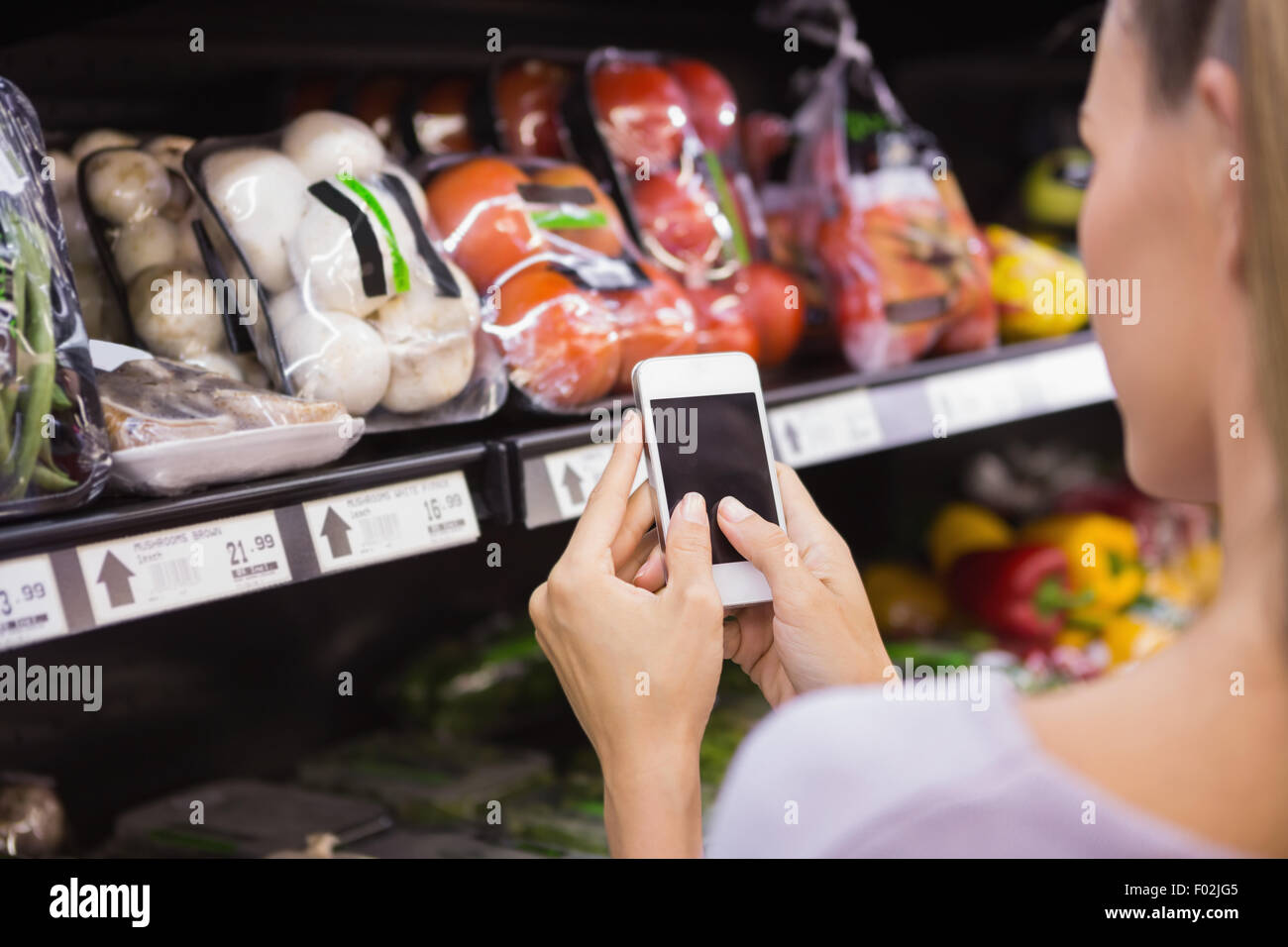 Woman reading her shopping list on smartphone Stock Photo - Alamy