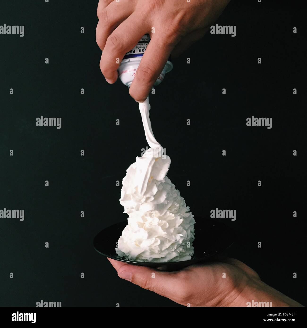 Hand holding a plate with whipped cream Stock Photo - Alamy