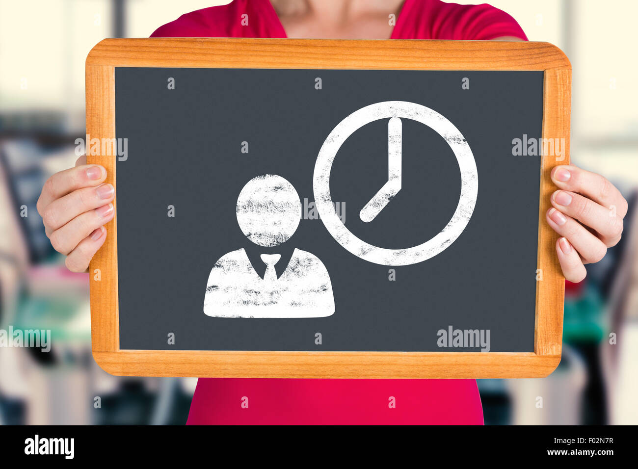 Composite image of woman showing chalkboard to camera Stock Photo - Alamy