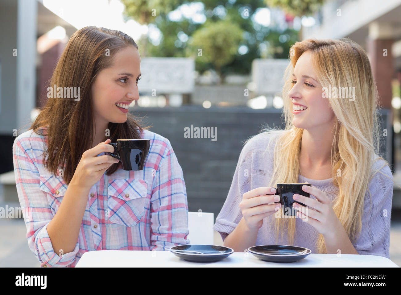 Happy women friends talking together Stock Photo - Alamy