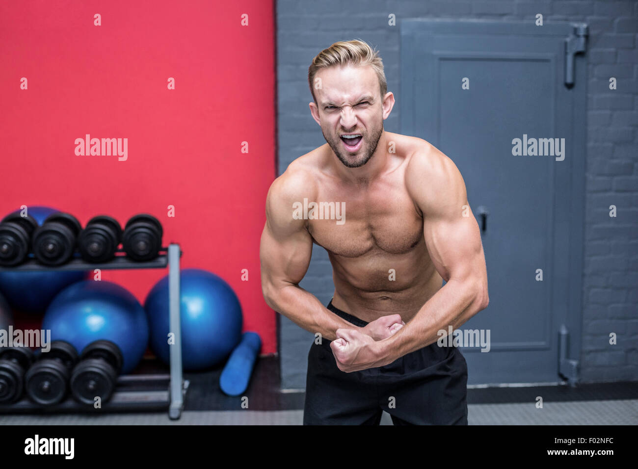 Muscular man flexing his muscles Stock Photo - Alamy