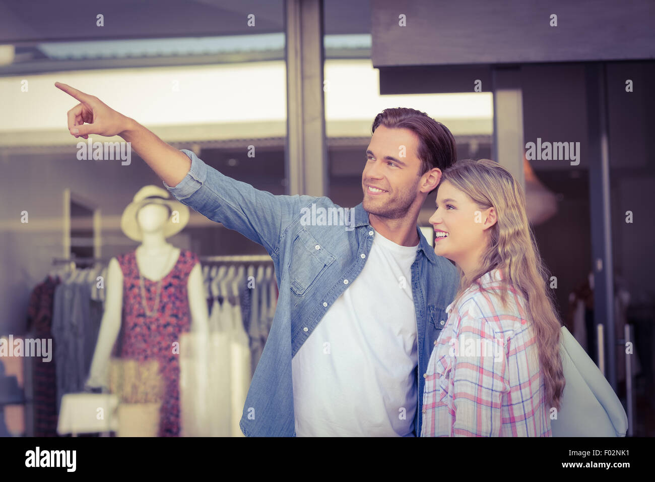 Happy couples looking and pointing far away Stock Photo - Alamy