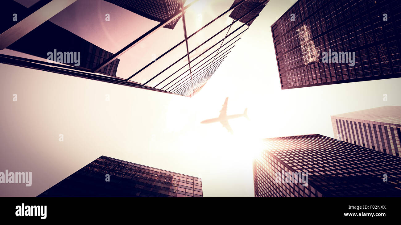 An airplane flying over buildings Stock Photo - Alamy