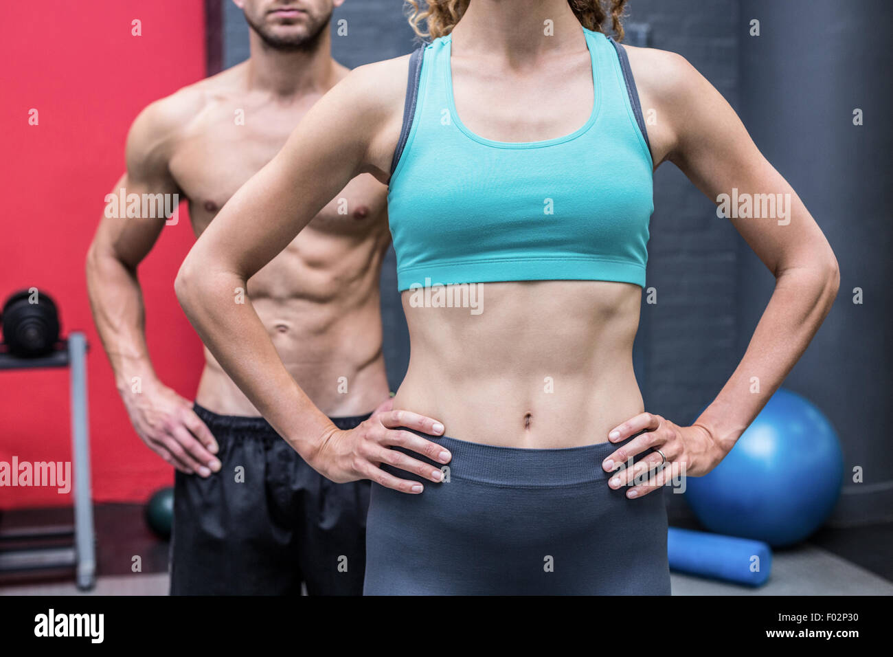 Muscular couple with hands on hips Stock Photo - Alamy