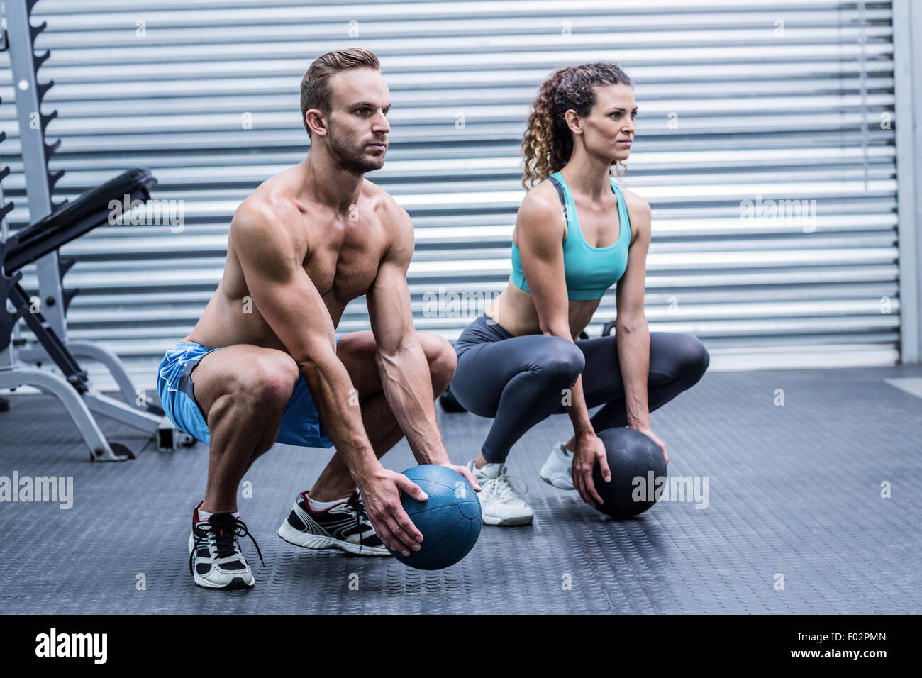 Muscular couple doing ball exercise Stock Photo - Alamy