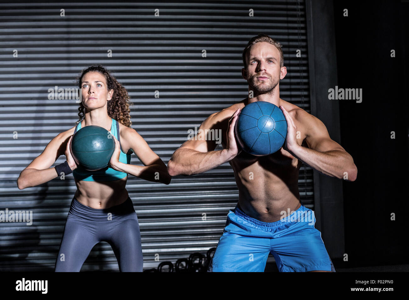 Muscular couple doing ball exercise Stock Photo - Alamy