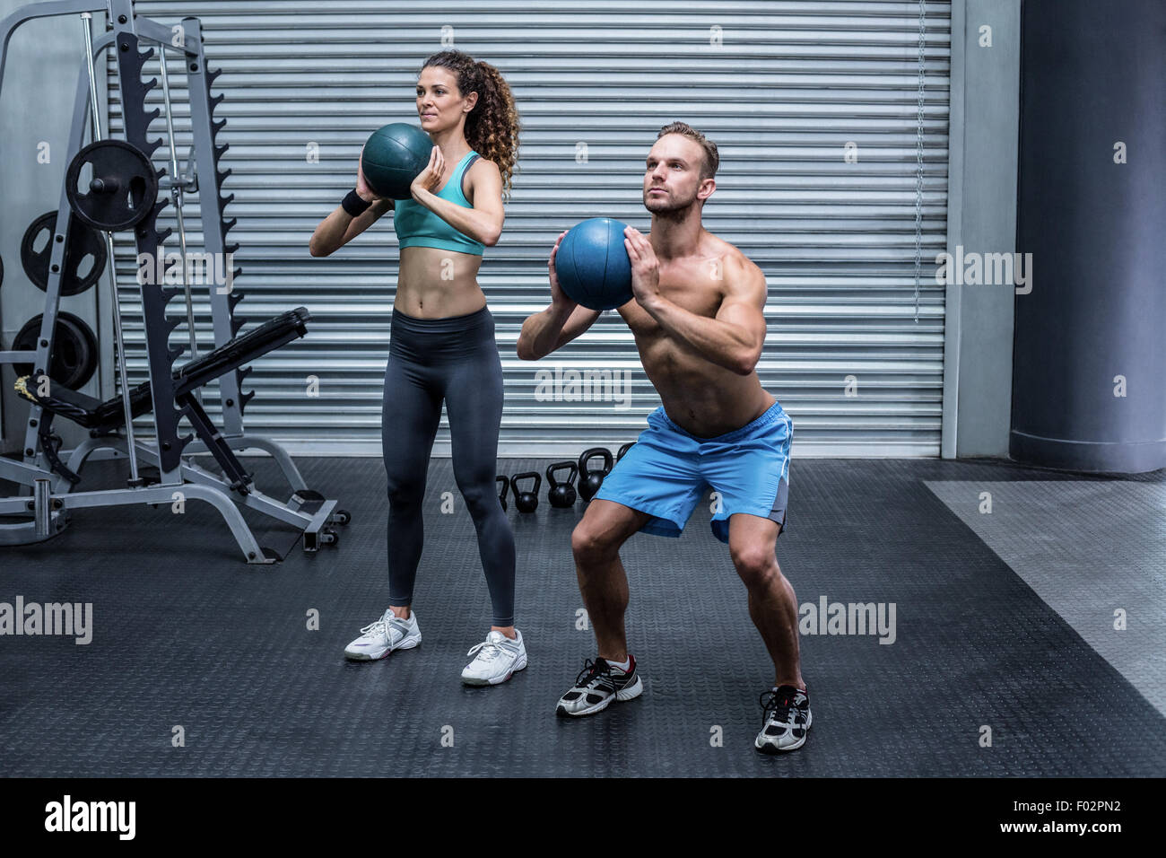 Muscular couple doing ball exercise Stock Photo - Alamy