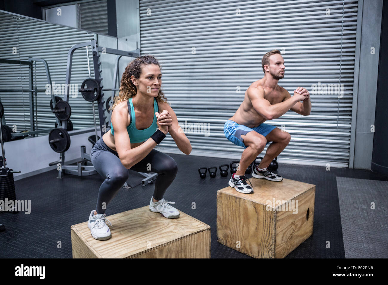 Muscular couple doing jumping squats Stock Photo - Alamy