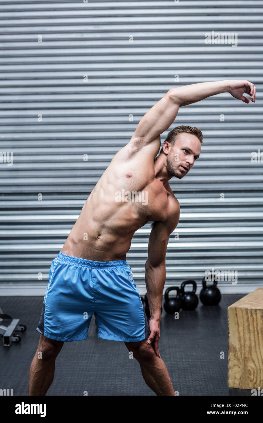 Muscular man doing arm stretchings Stock Photo - Alamy