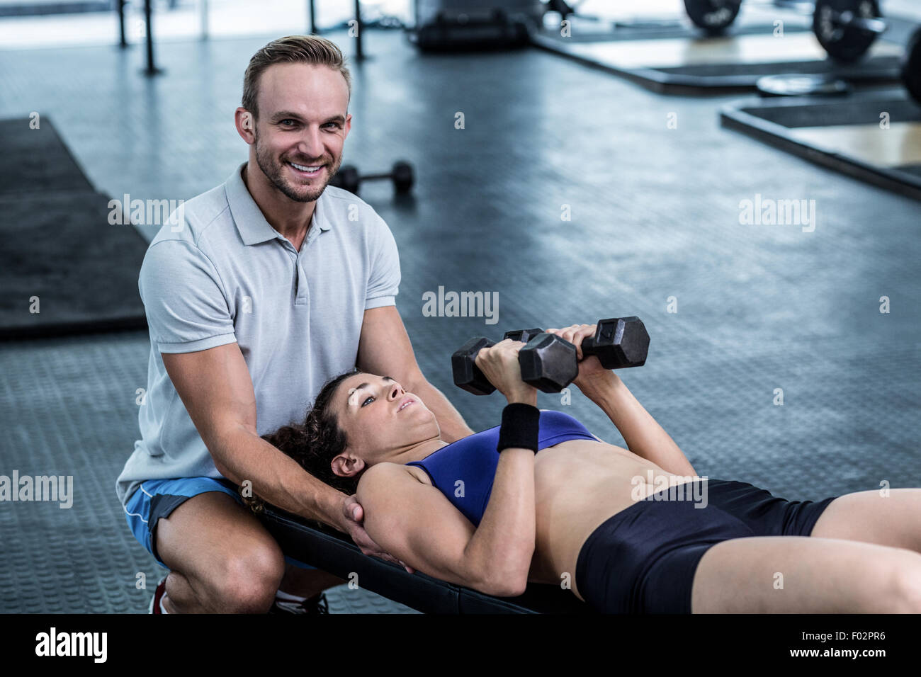A muscular woman about to lift dumbbells Stock Photo - Alamy